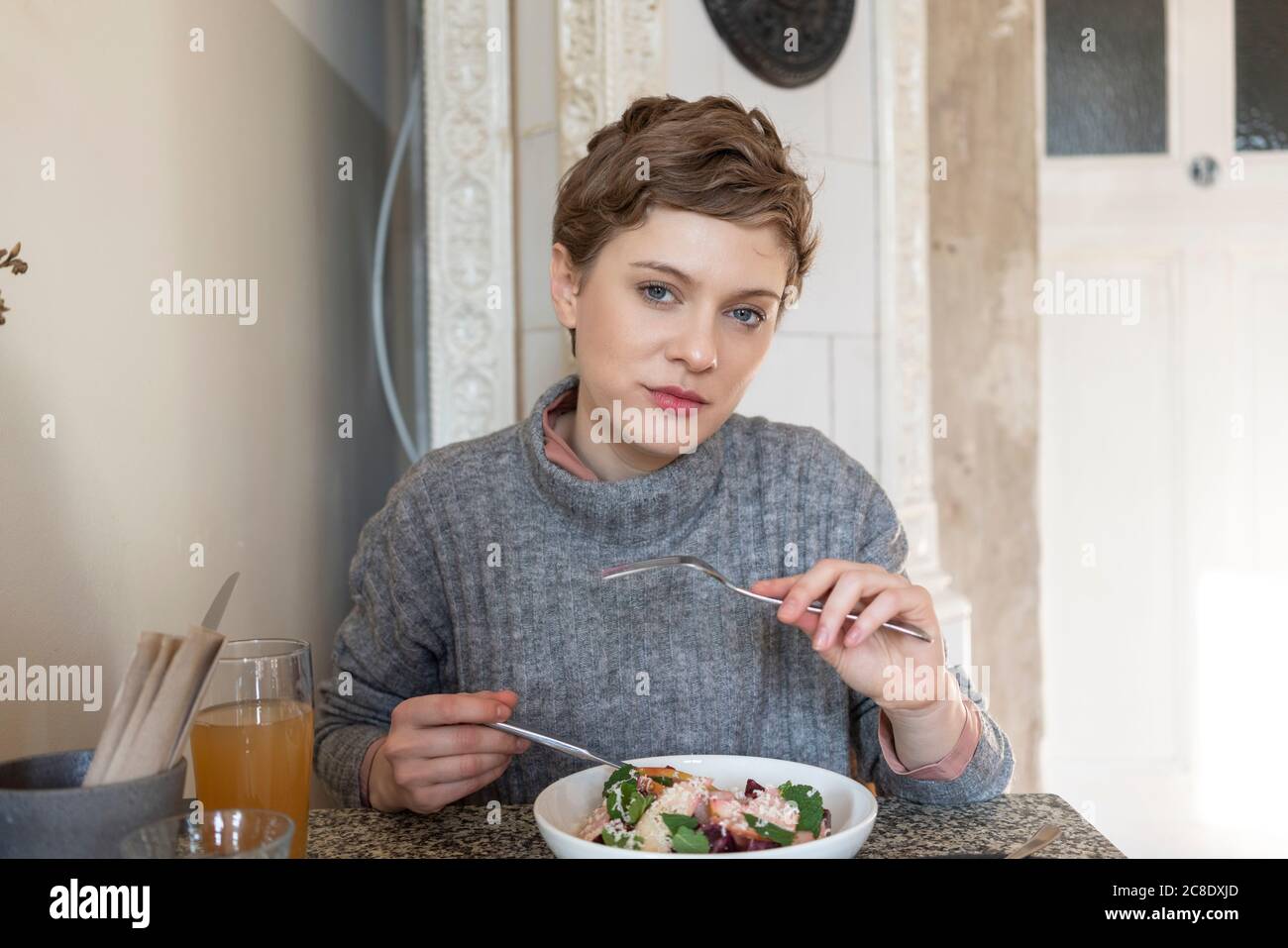 Beautiful short haired woman eating meal at cafeteria Stock Photo - Alamy