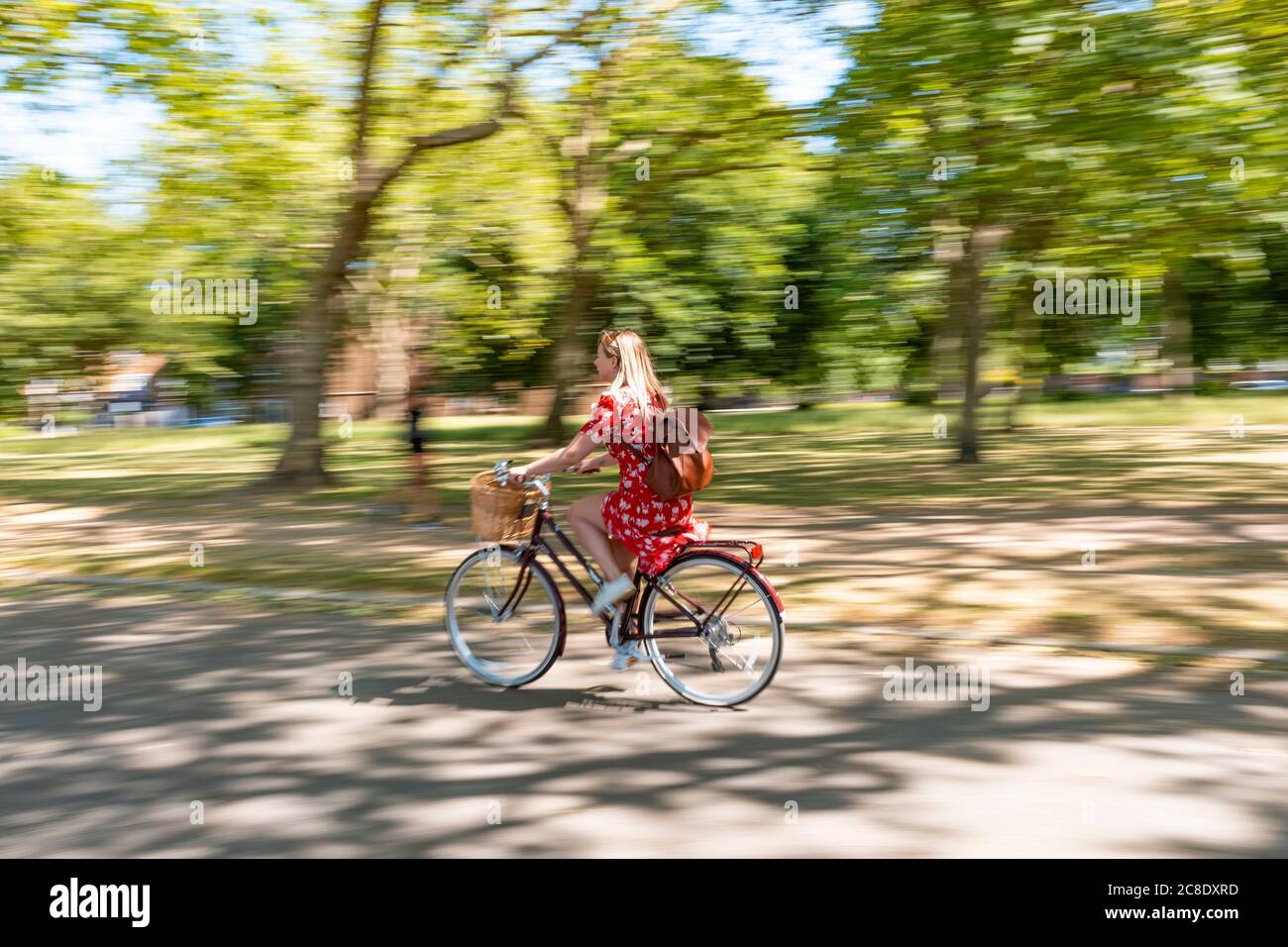 Woman red dress riding bicycle hi-res stock photography and images - Alamy