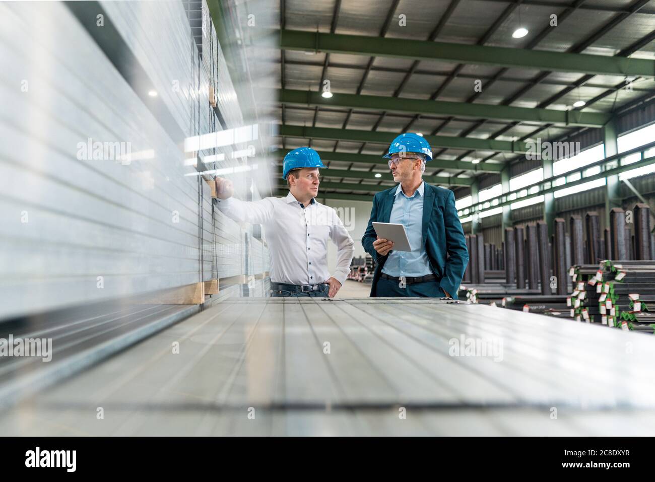 Two businessmen having meeting factory hall hi-res stock photography ...