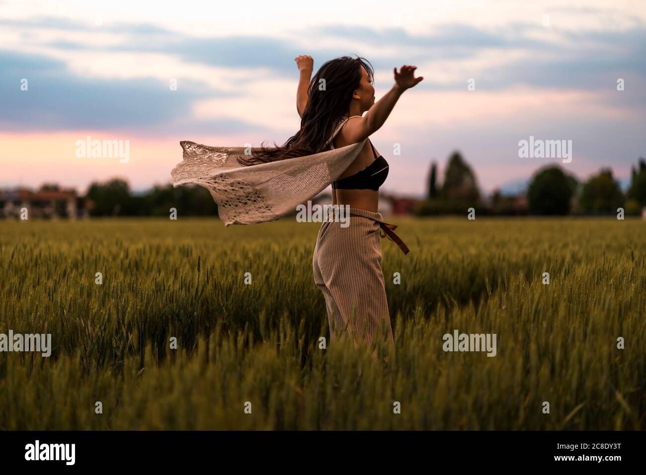 Woman dancing at field in the evening light Stock Photo - Alamy