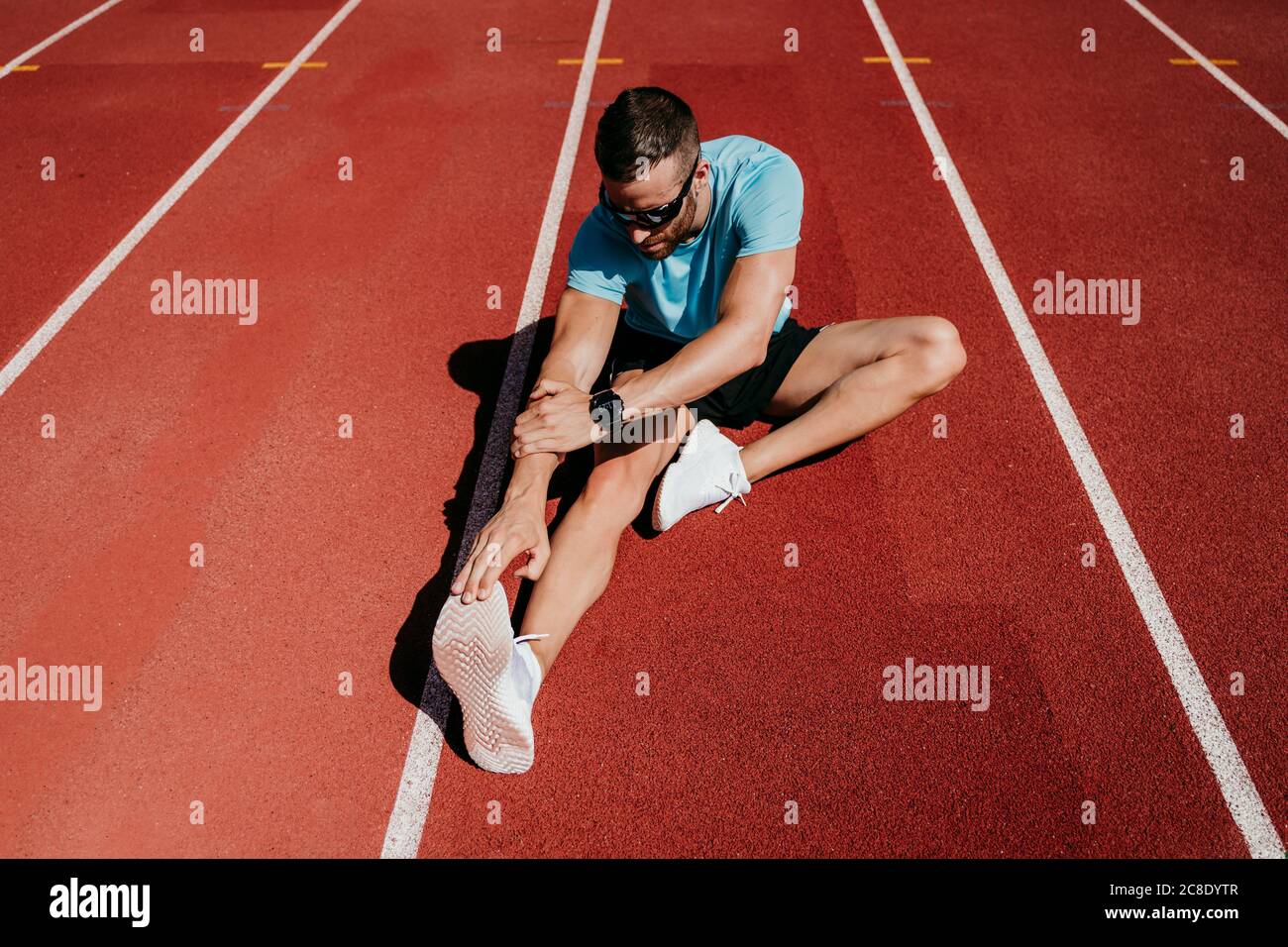 Track runner stretching hi-res stock photography and images - Alamy