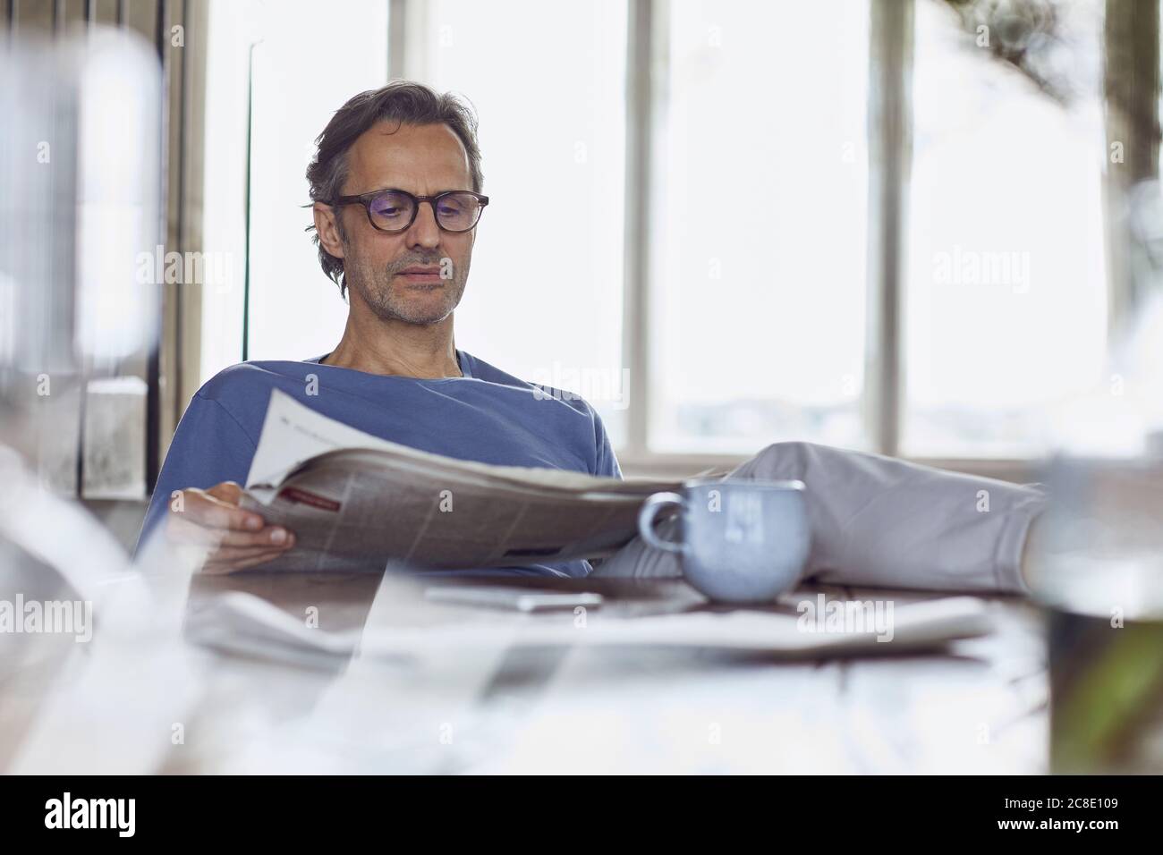 Man reading newspaper table hi-res stock photography and images - Alamy