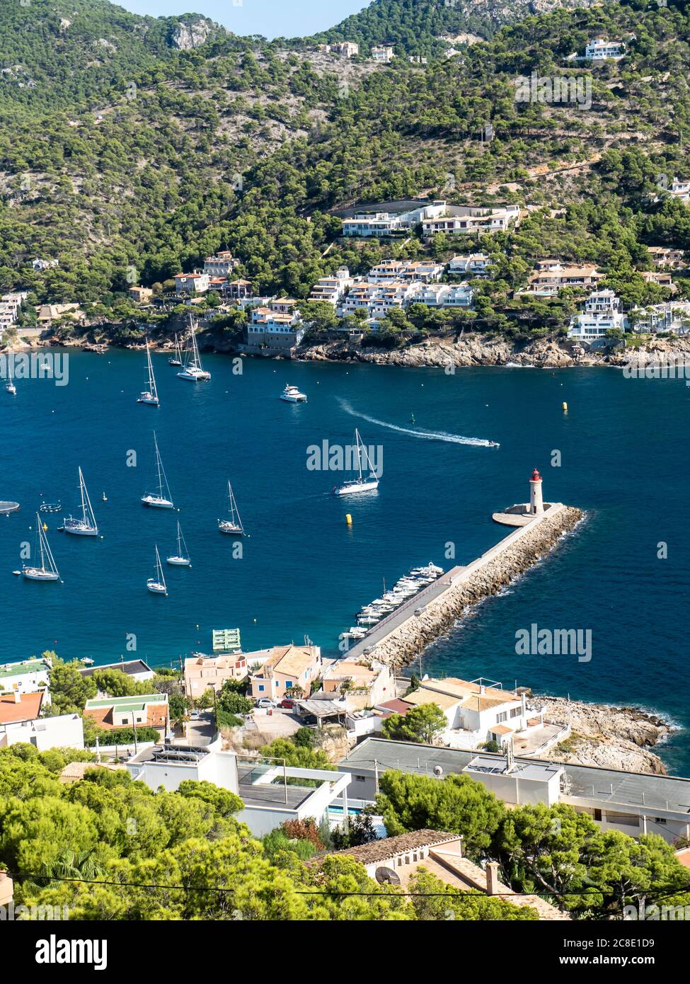 Spain, Mallorca, Andratx, Sailboats sailing in bay of coastal town in ...