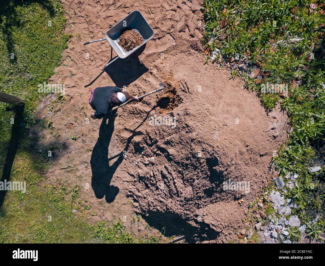 Aerial view of man loading sand on wheelbarrow Stock Photo - Alamy