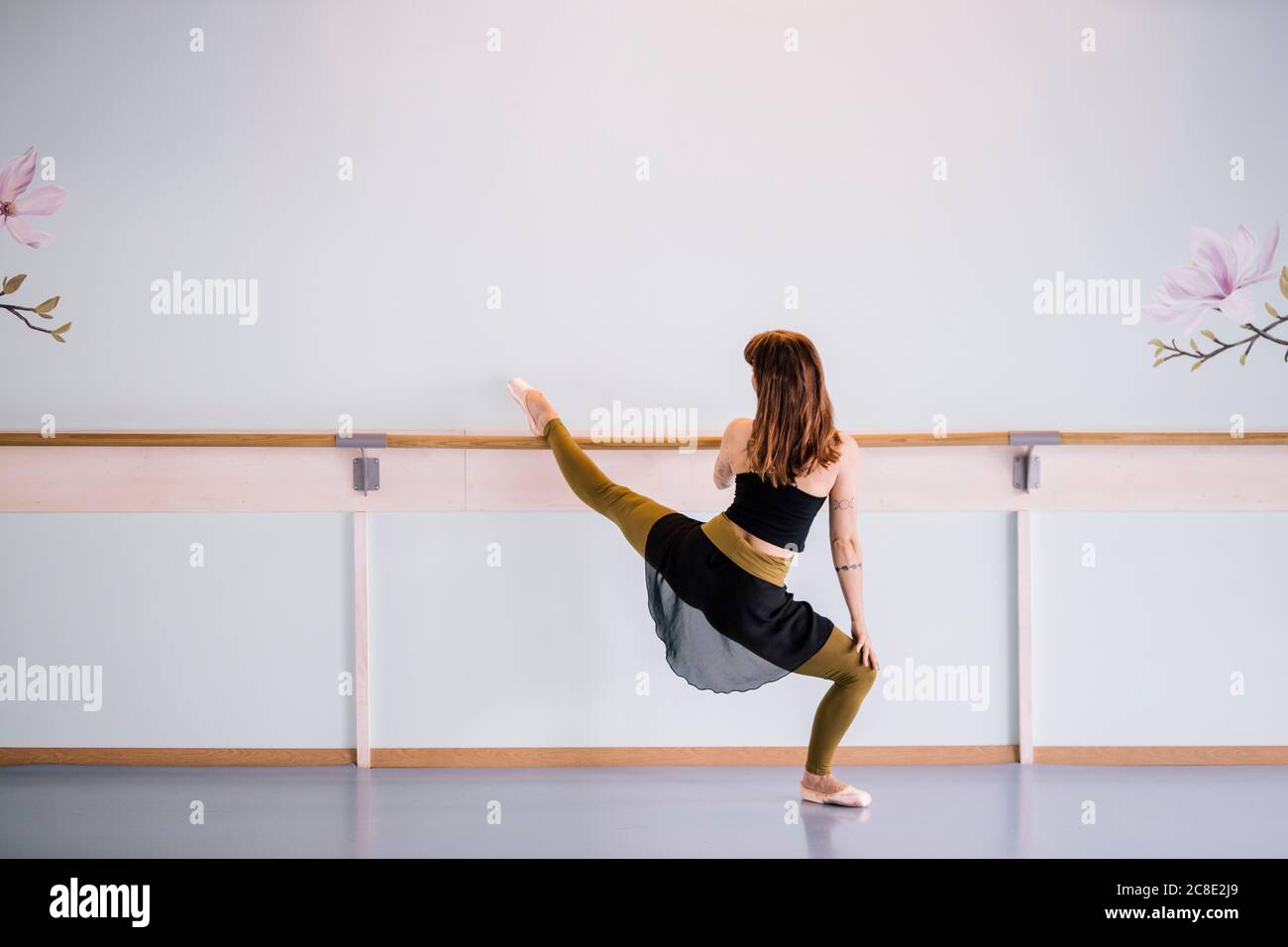 Ballerina stretching leg in dance studio Stock Photo - Alamy