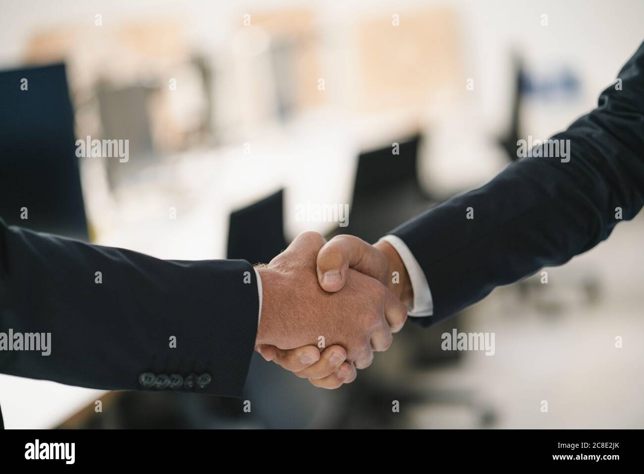 Two businessmen shaking hands Stock Photo - Alamy
