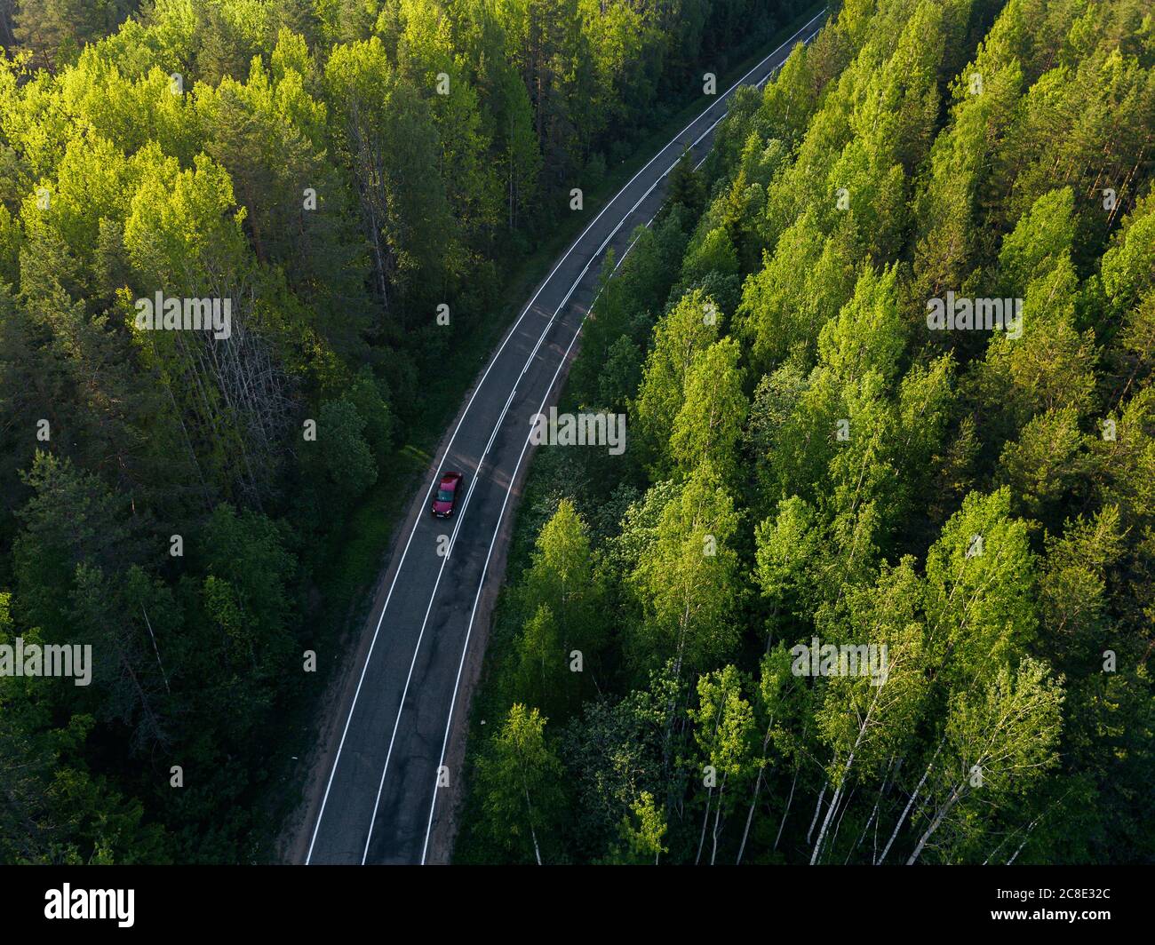 Aerial view of asphalt road cutting through vast green forest hi-res ...