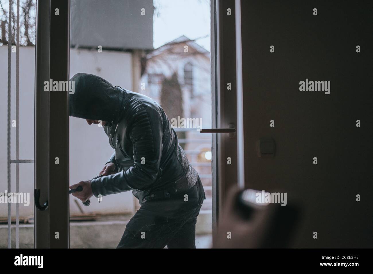 Robber with wrecking bar entering from the window Stock Photo - Alamy