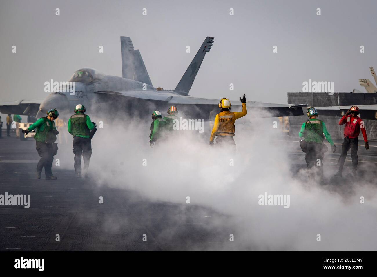 A U.S. Navy deck crew prepare to launch a F/A-18E Super Hornet attached ...