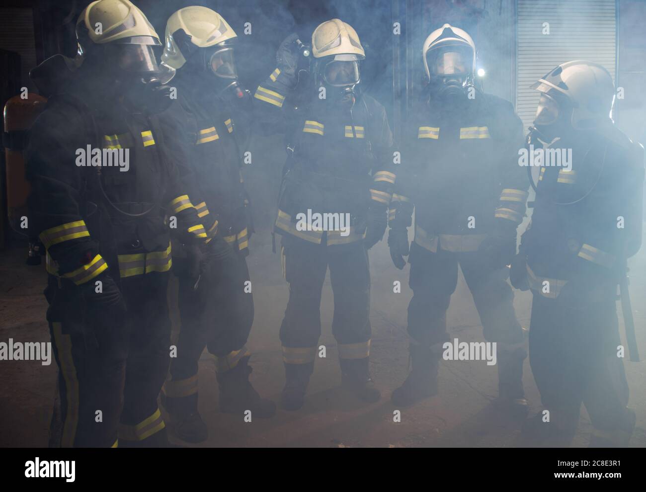 Portrait of group of firefighters in the middle of the smoke of the ...