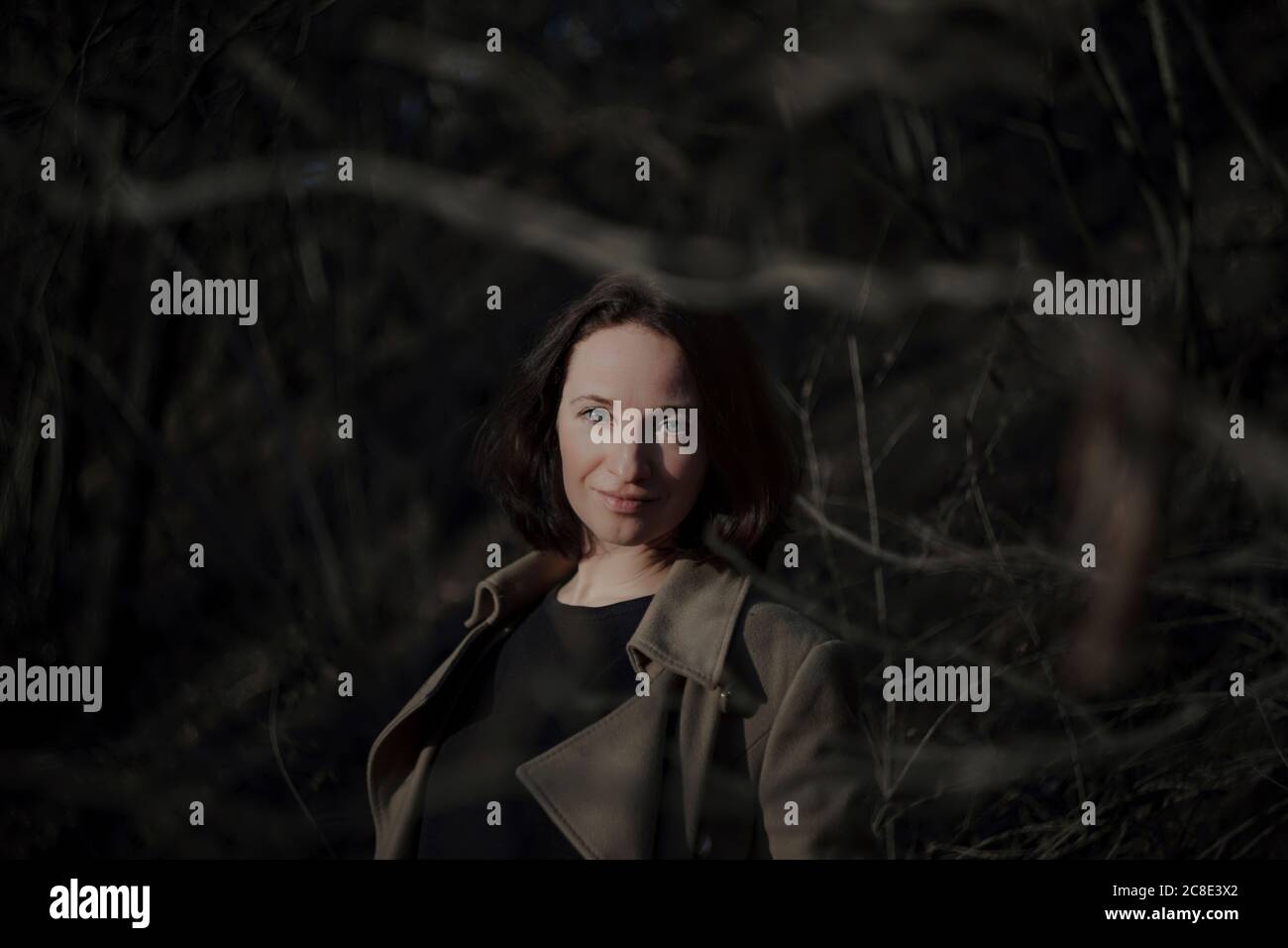 Beautiful mature woman standing in forest Stock Photo - Alamy