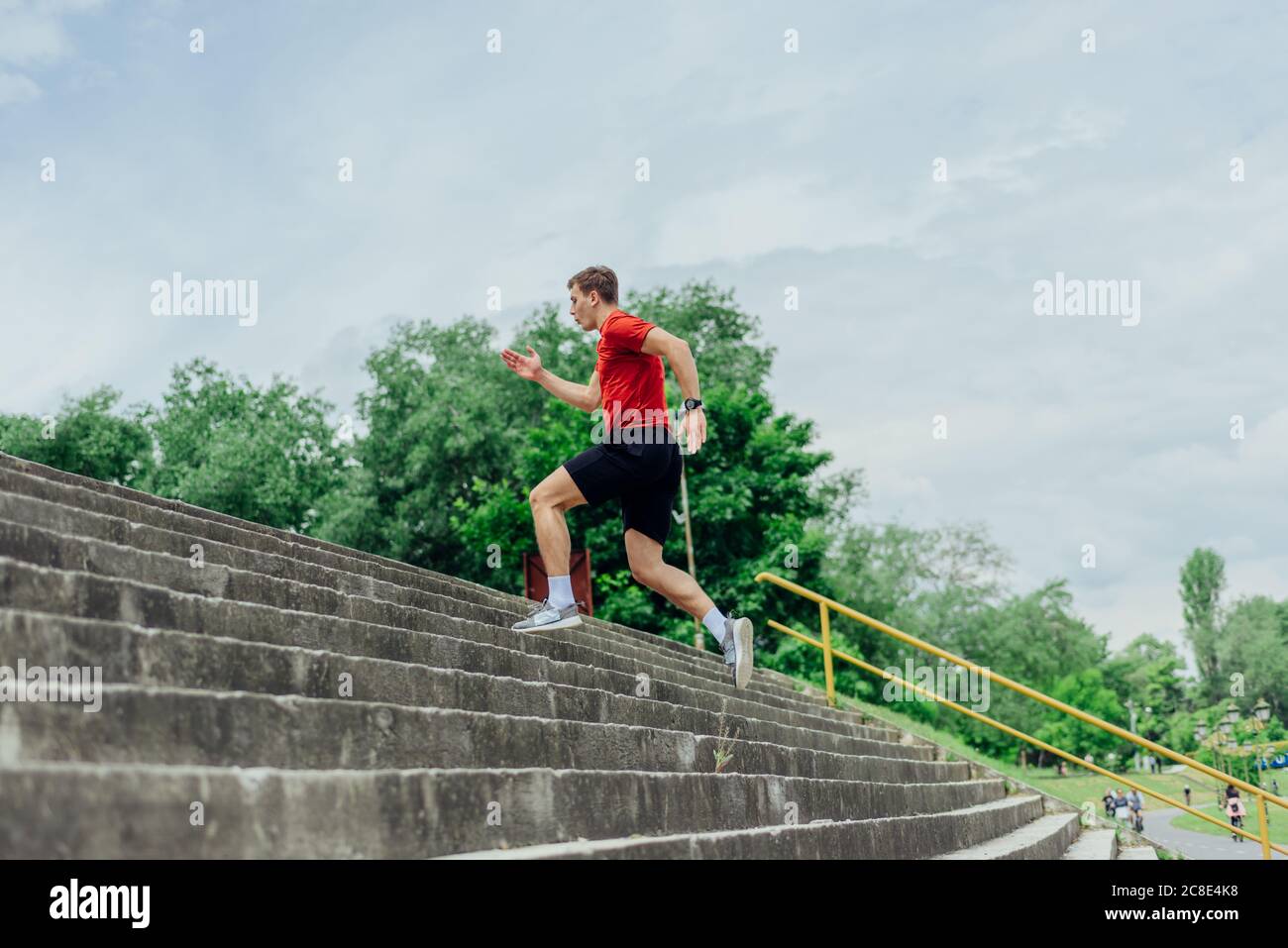 Fit male athlete performing stairs workout, running up climbing stairs ...