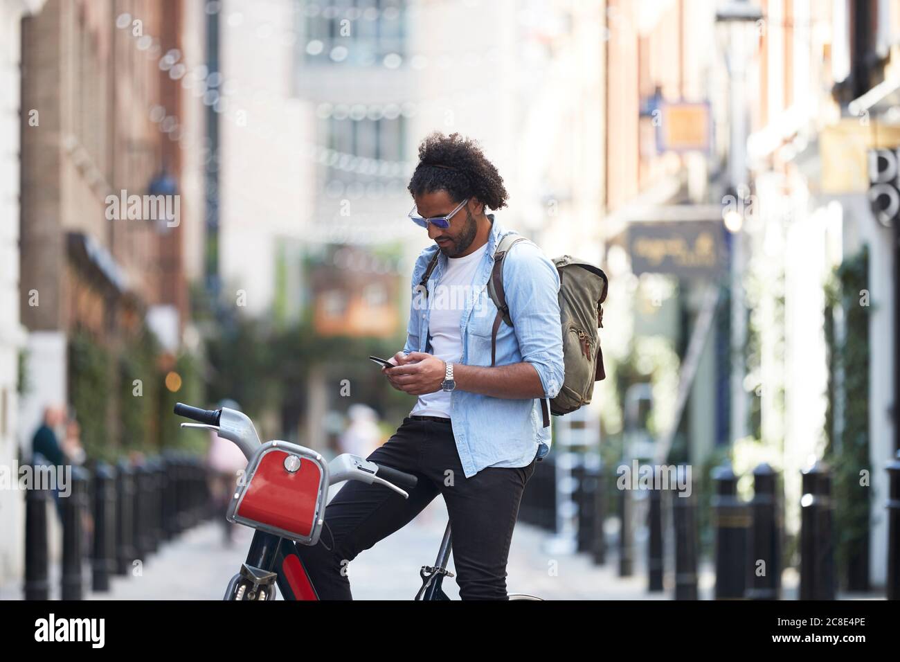 Cyclist using phone while riding london hi-res stock photography and ...