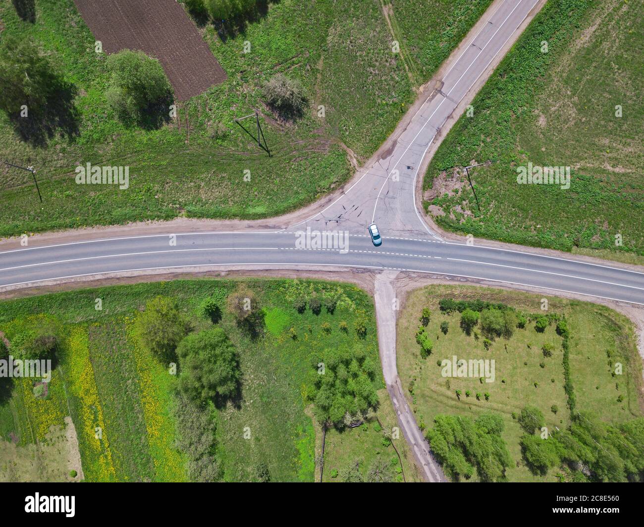 Aerial view of car driving past intersection on country road hi-res ...