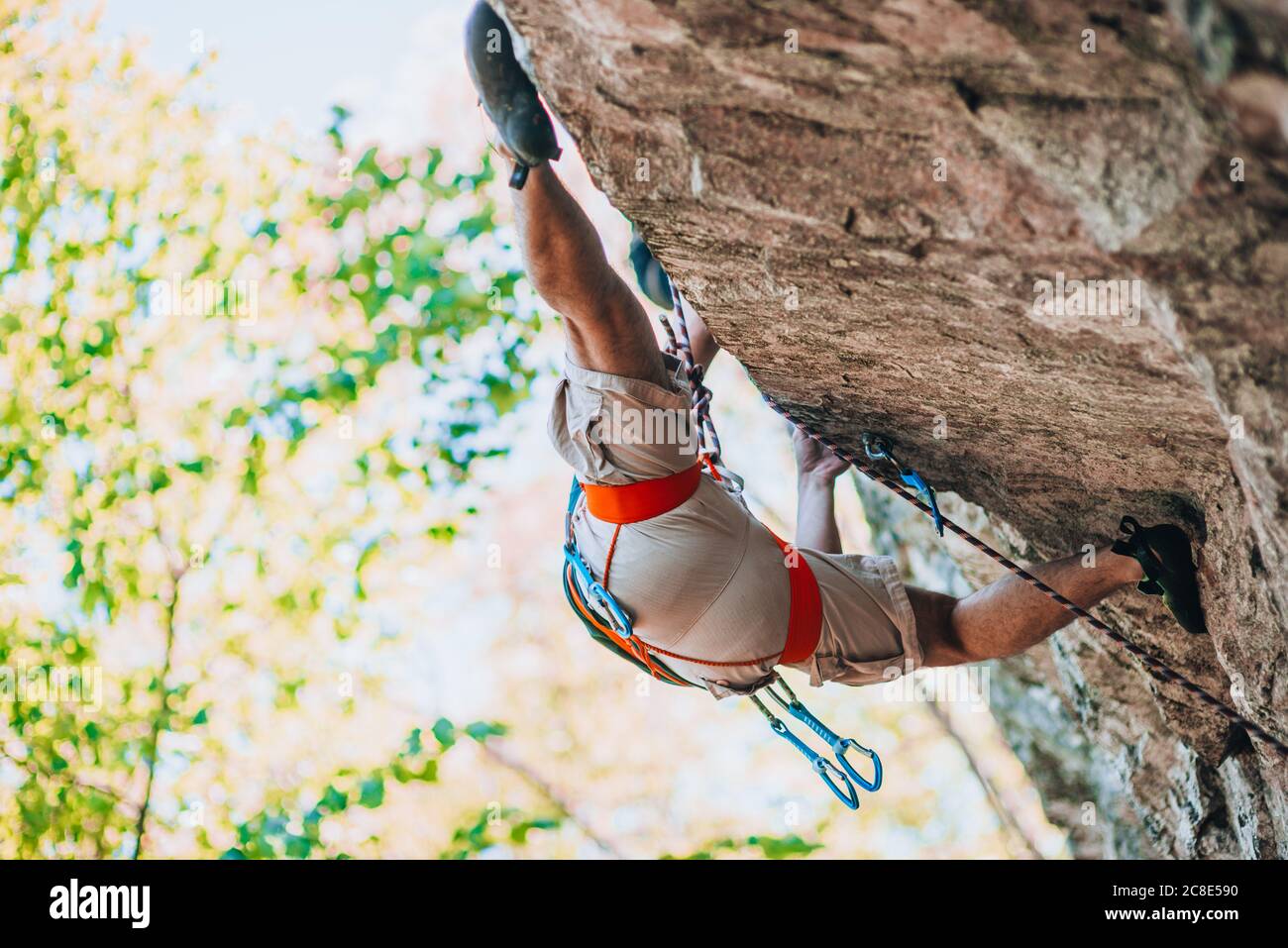 Rock climber climbs the cliff using ropes and equipment, the employment ...