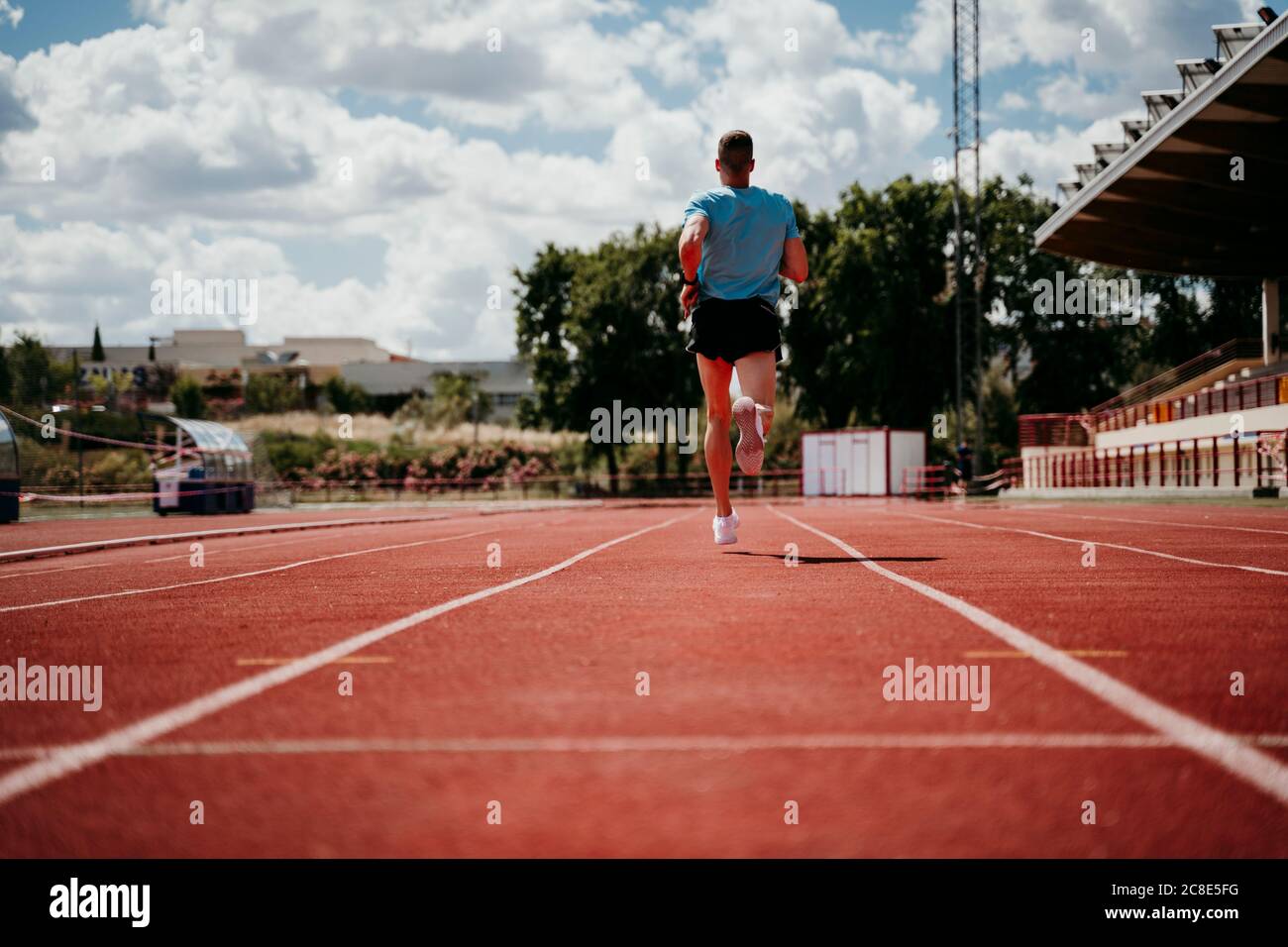 Male athlete running on tartan track Stock Photo - Alamy