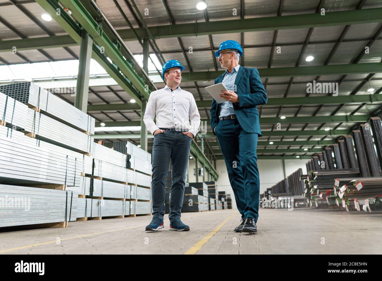 Two businessmen talking in a factory Stock Photo - Alamy