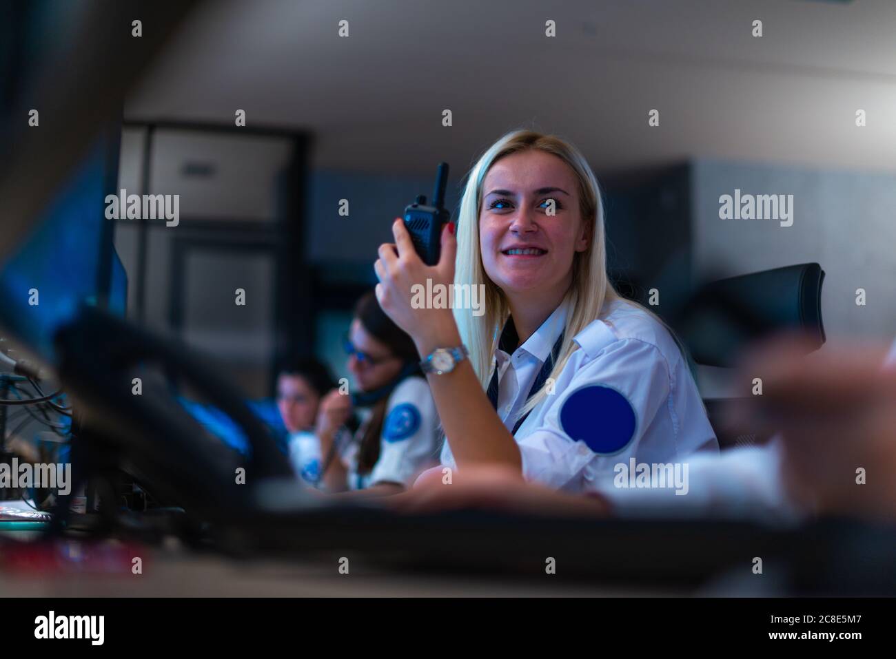 Happy security data center operator colleagues (coworkers) smiling and ...