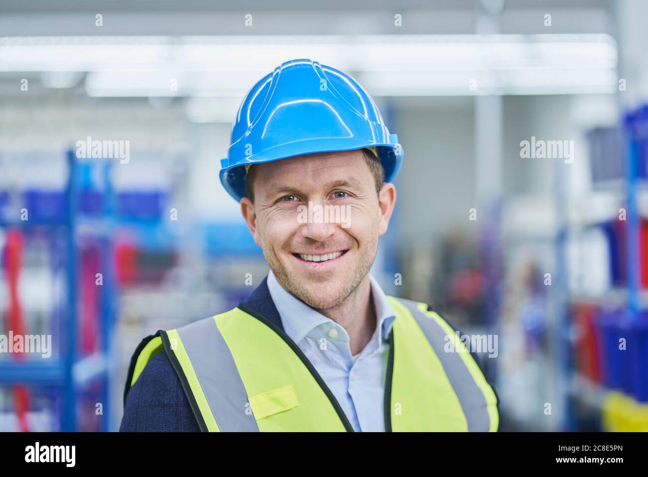 Happy male supervisor wearing hardhat and reflective clothing in ...
