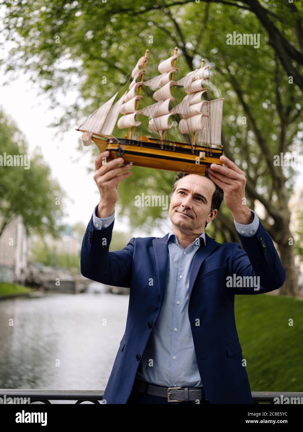 Mature businessman holding model sailing ship on a bridge Stock Photo ...