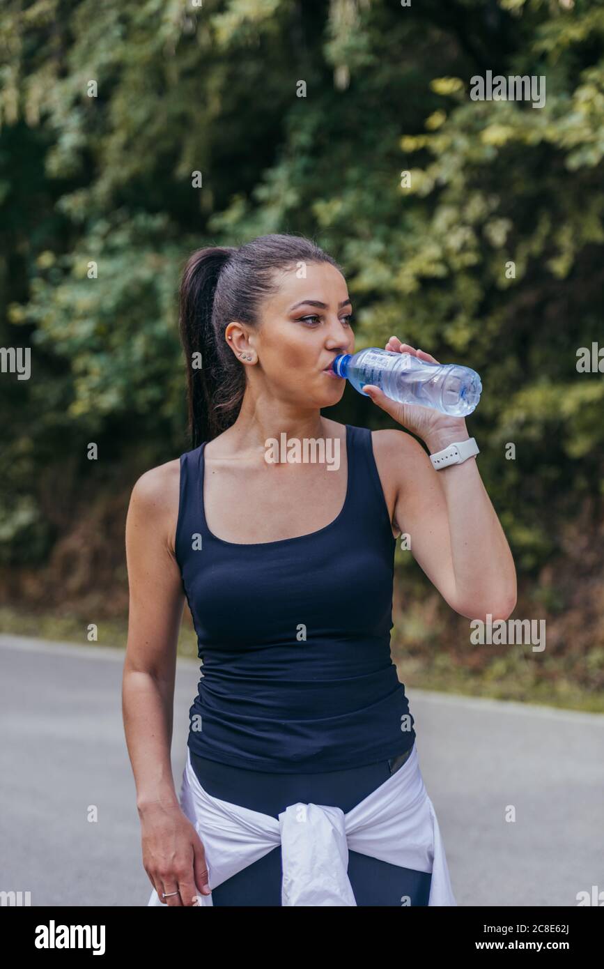 Female athlete drinking water, refreshing, hydrating after a long exhausting workout, run Stock ...