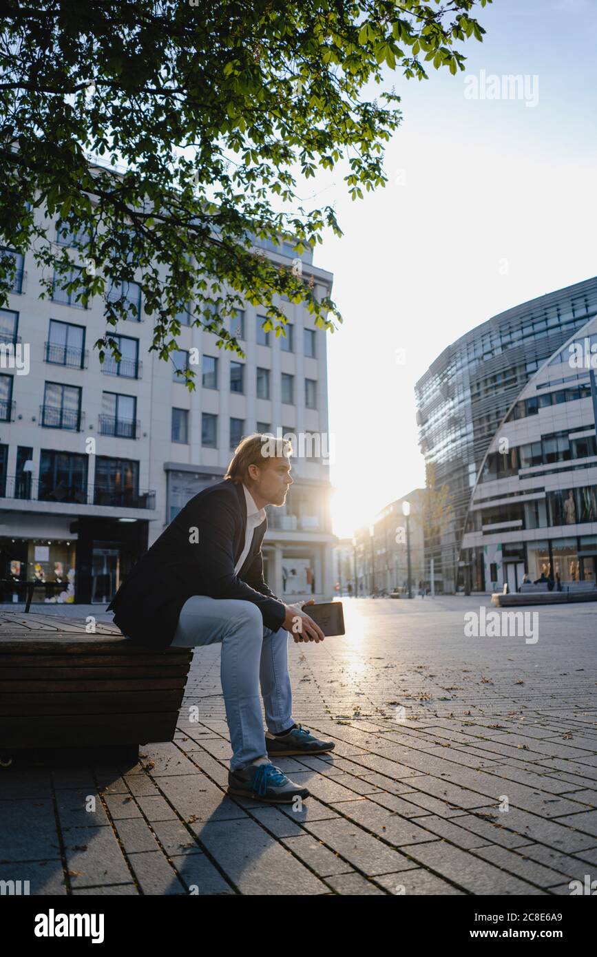 Man sitting on bench at sunset hi-res stock photography and images - Alamy