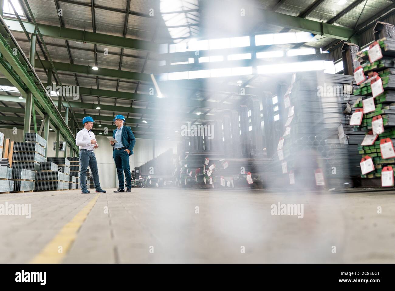 Two businessmen talking in a factory Stock Photo - Alamy
