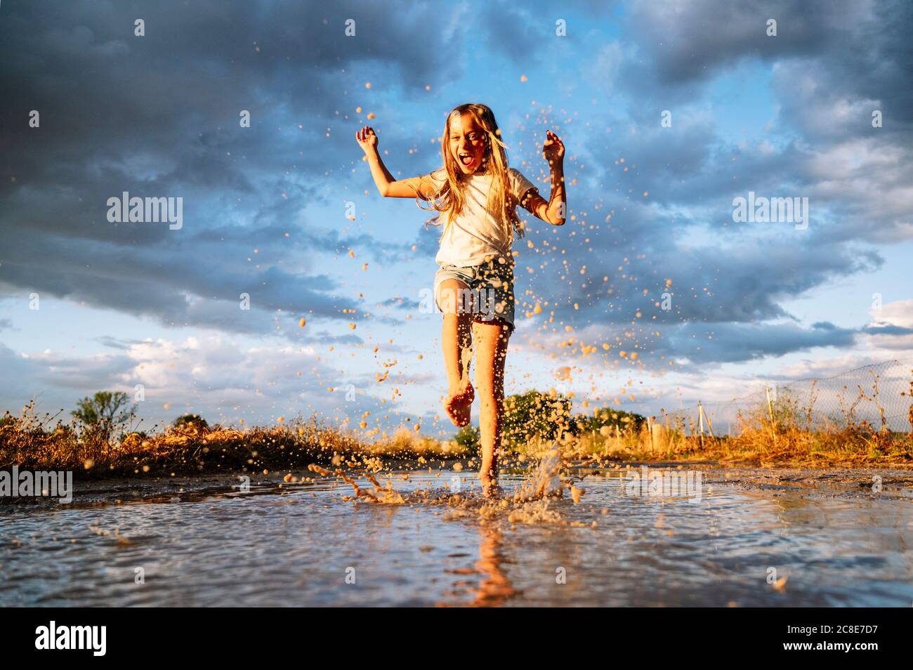 Girl splashing puddle hi-res stock photography and images - Alamy