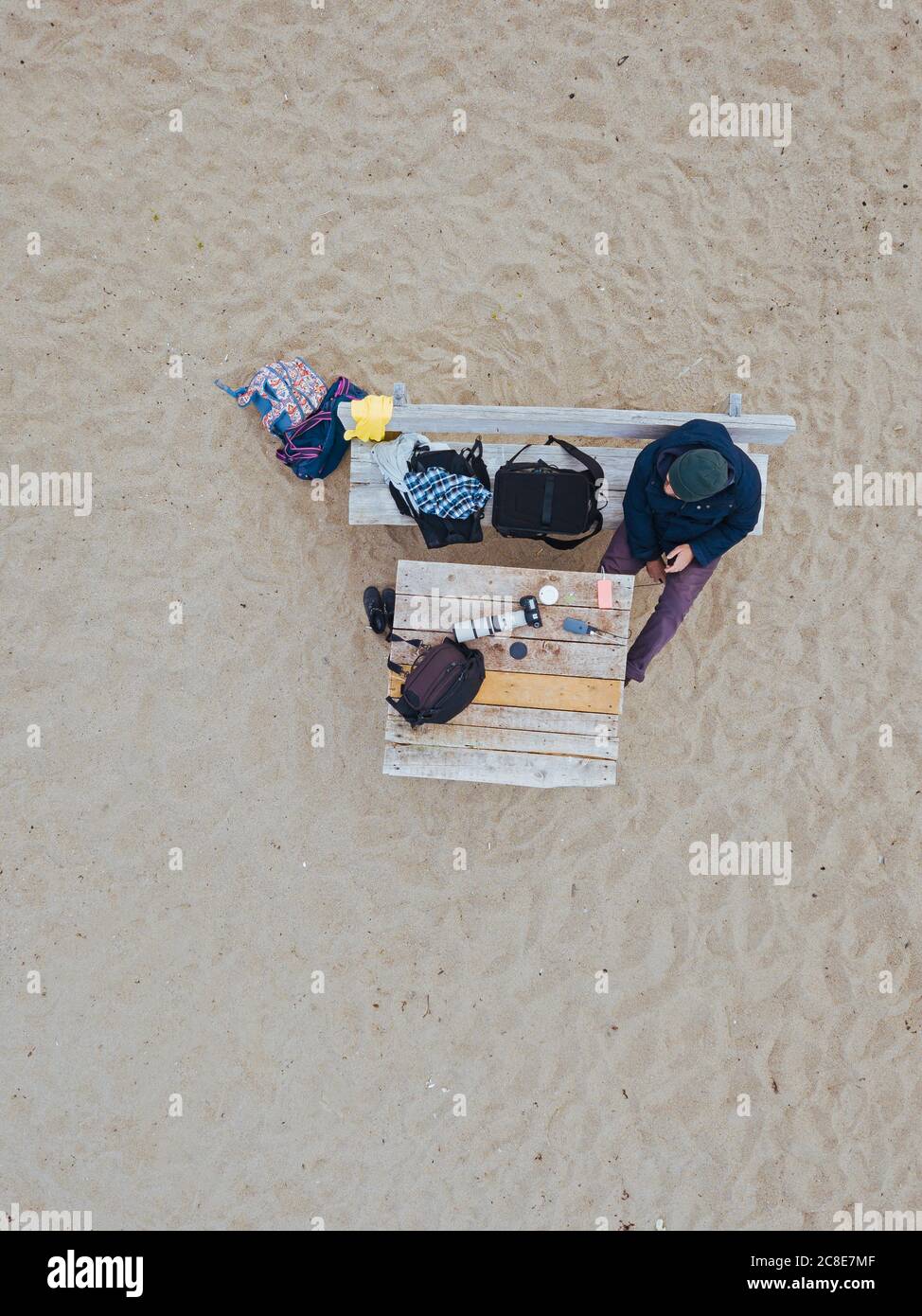 Aerial view of man relaxing on bench at beach Stock Photo - Alamy