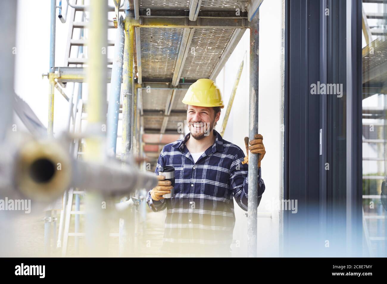 Happy worker having a coffee break on a construction site Stock Photo ...