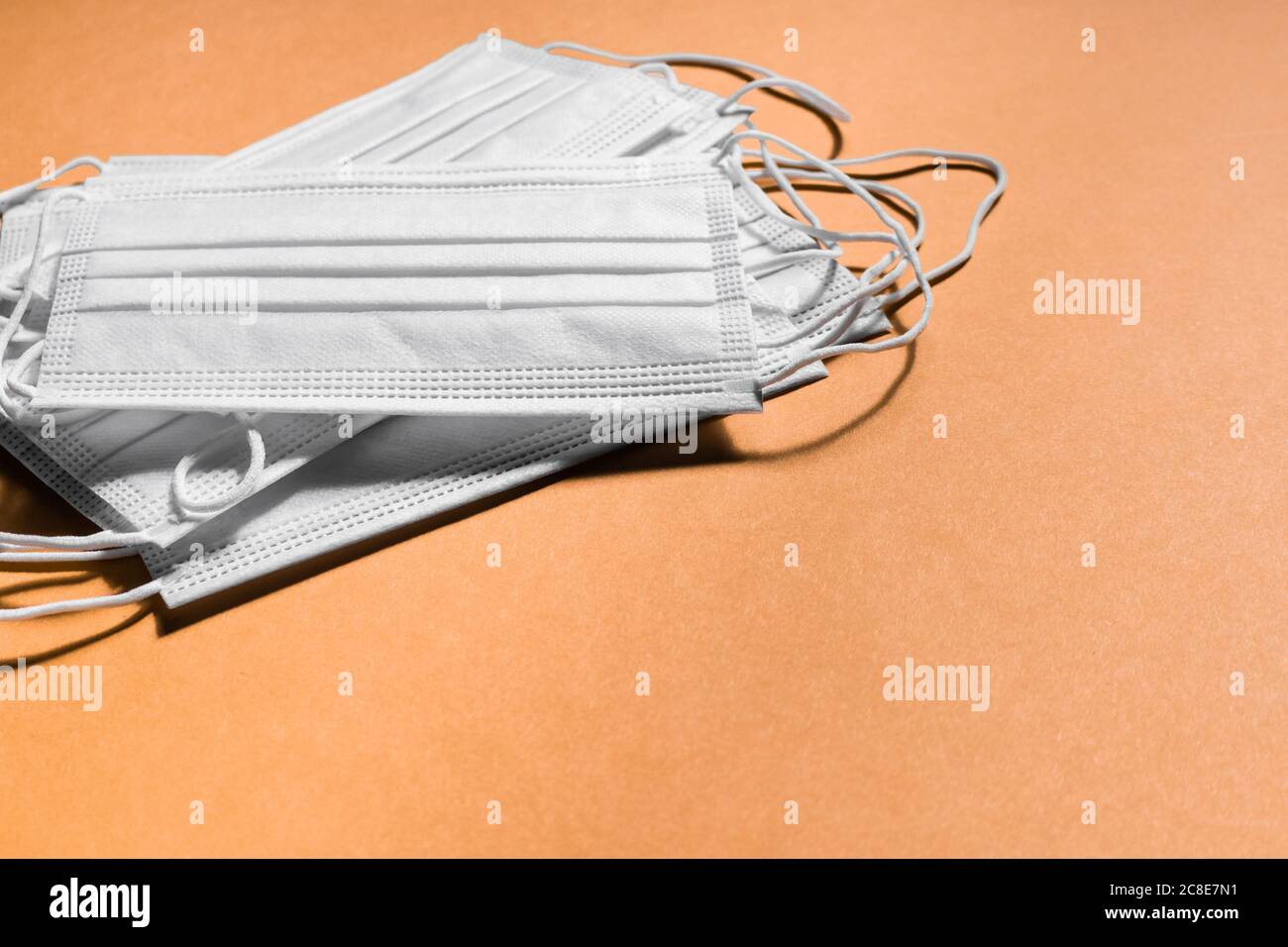 Stack of face masks on orange background Stock Photo - Alamy
