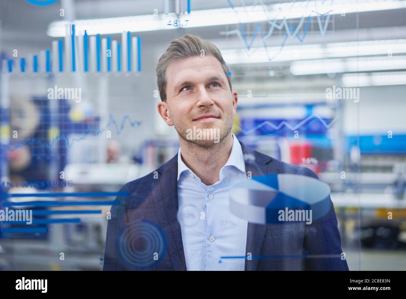 Male supervisor looking at graphs on glass in industry Stock Photo - Alamy