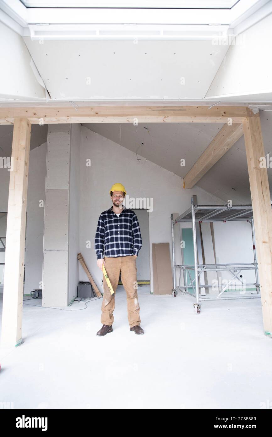 Construction worker standing in house under construction Stock Photo ...
