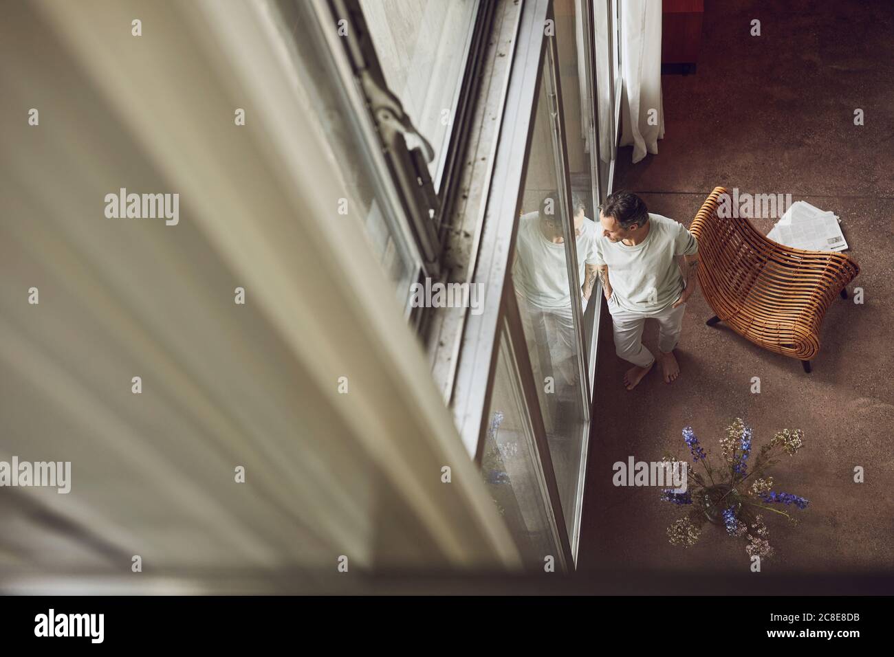 Senior man looking out of window in a loft flat Stock Photo - Alamy