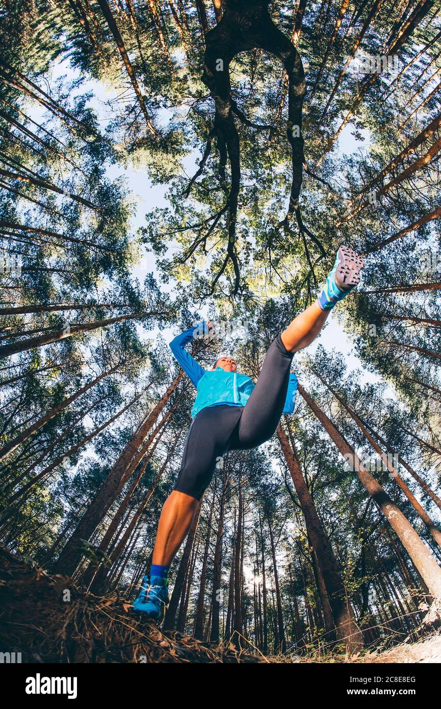 Mature woman jumping against trees in forest Stock Photo - Alamy