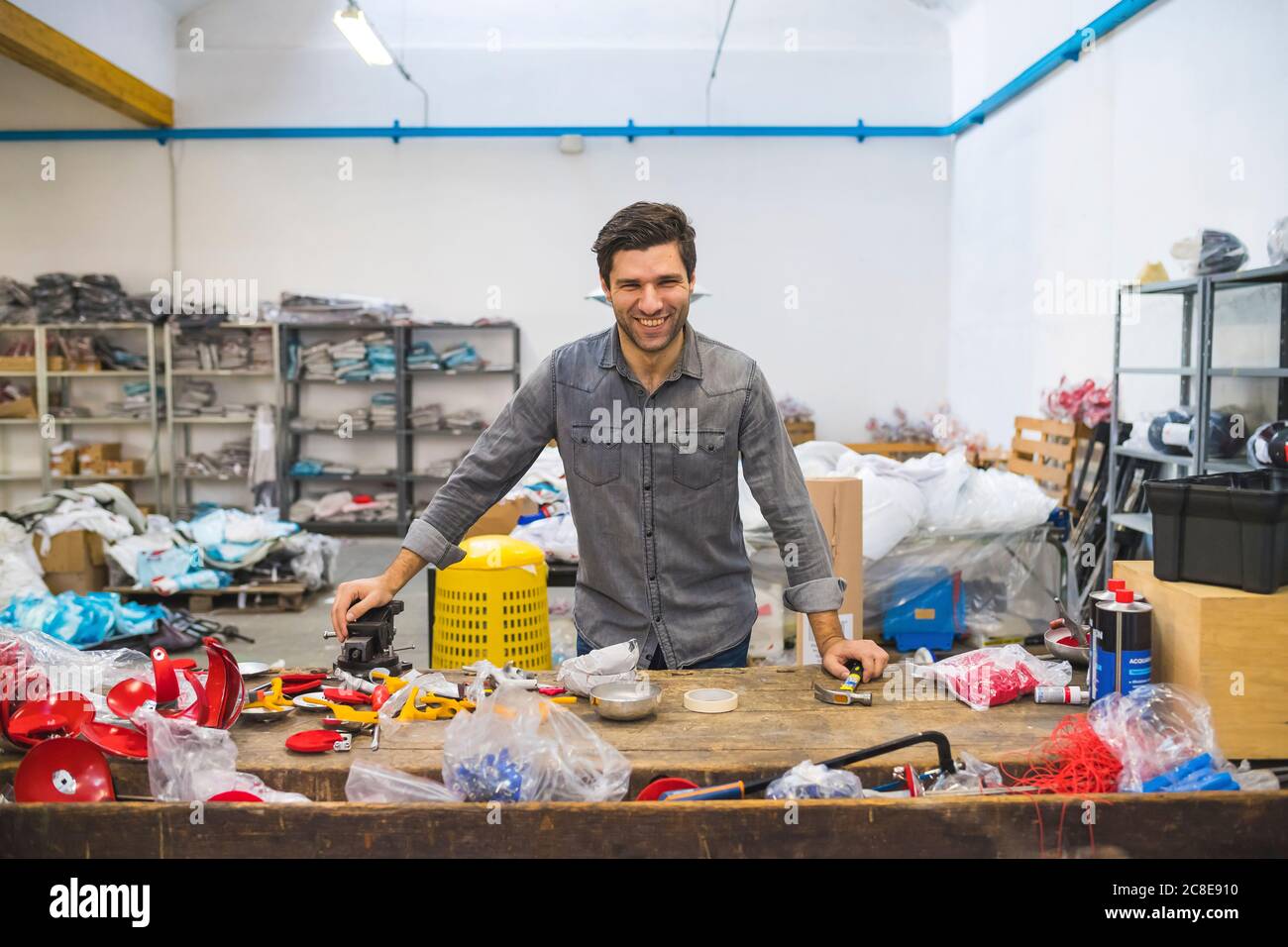 Portrait of smiling man at workbench with fencing supplies Stock Photo ...