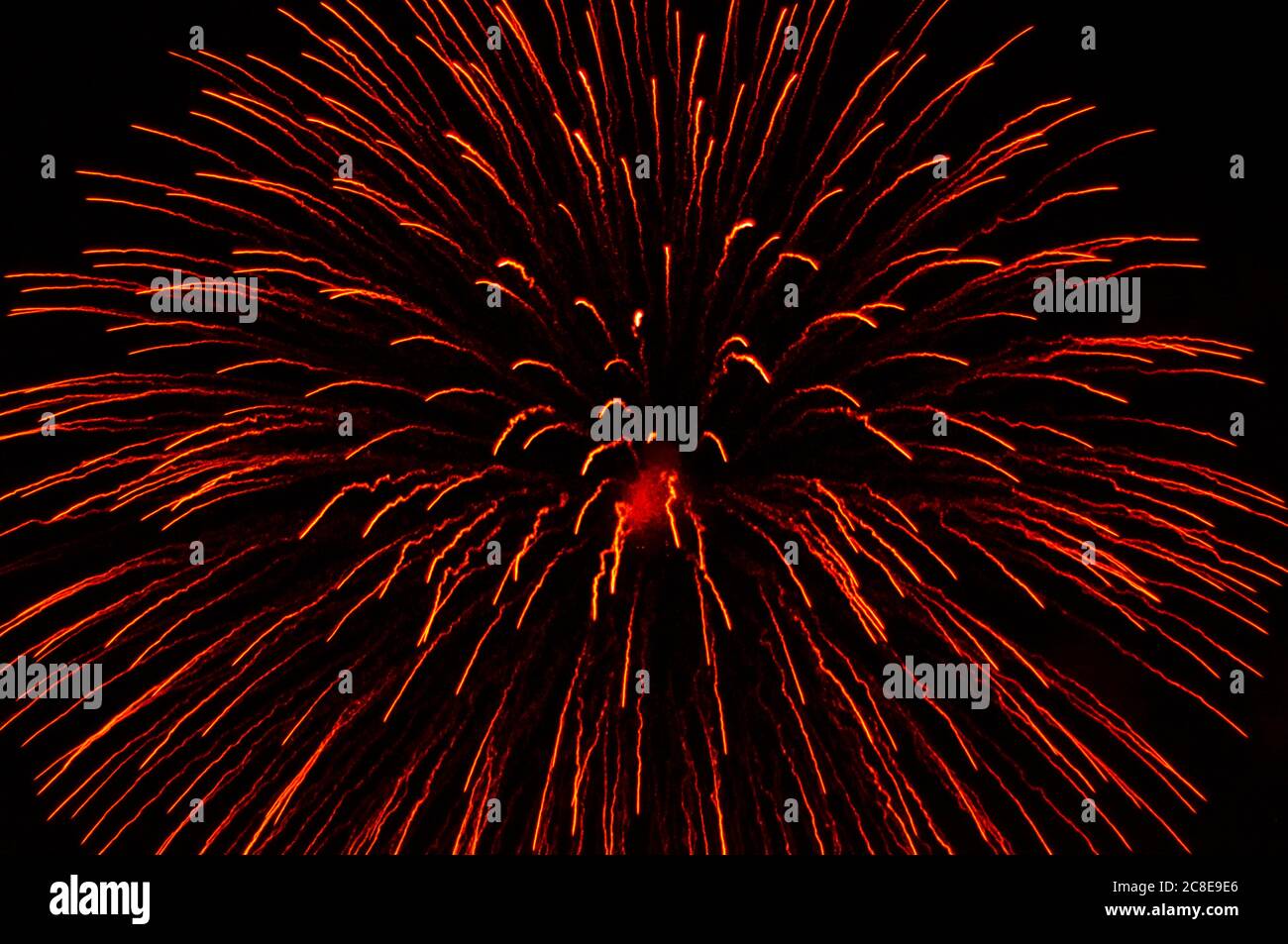 Red fireworks exploding against night sky Stock Photo - Alamy
