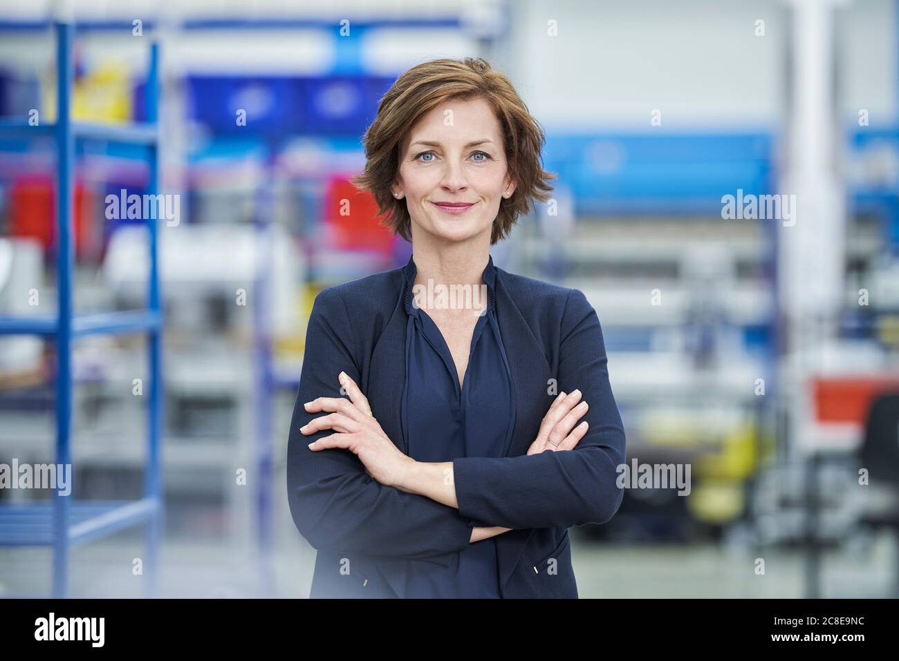 Confident female manager standing arms crossed in factory Stock Photo ...