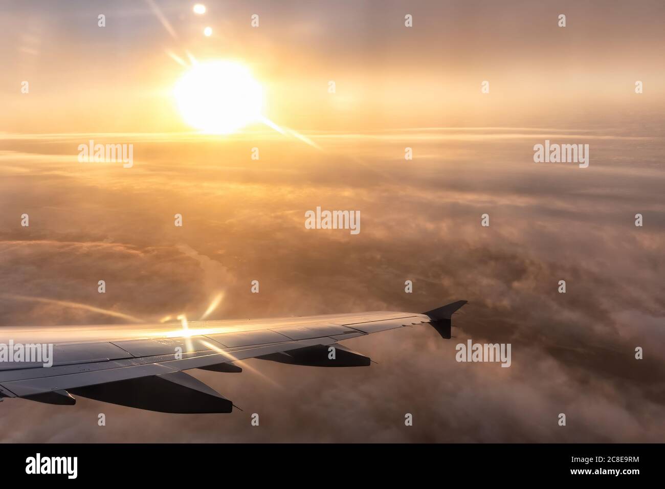 View on passenger aircraft right wing. Sunset shines as a golden light ...