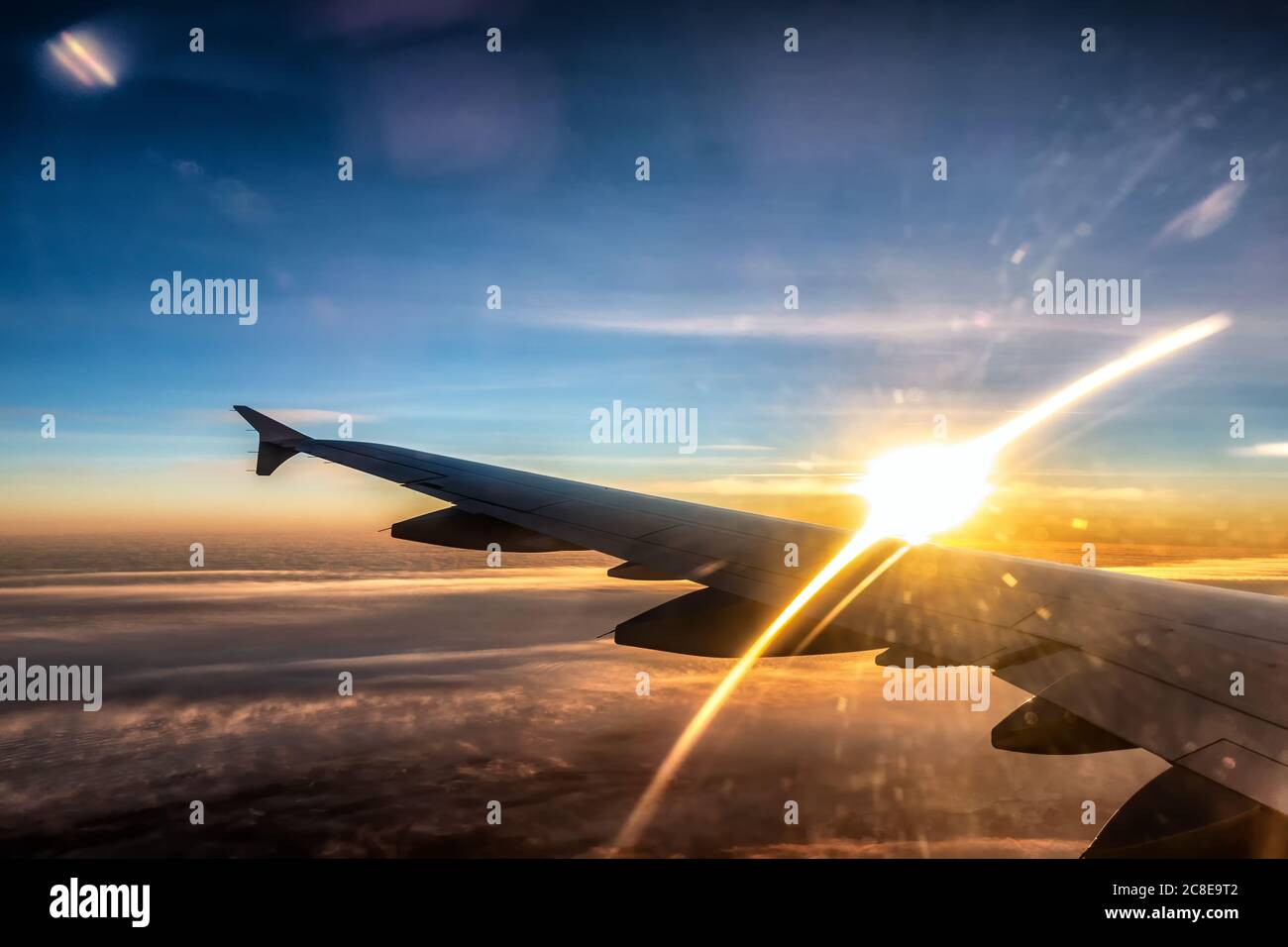 View on passenger aircraft left wing. Sunset shines as a golden light ...