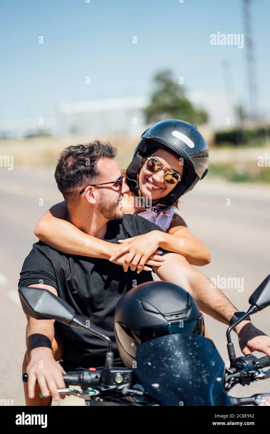 Couple sitting on motorbike Stock Photo - Alamy