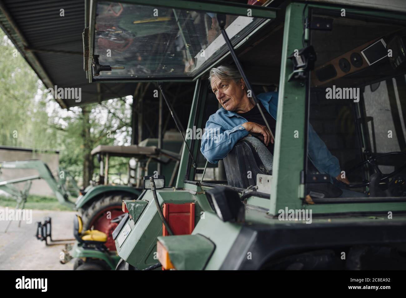 Senior man driving tractor on a farm Stock Photo - Alamy