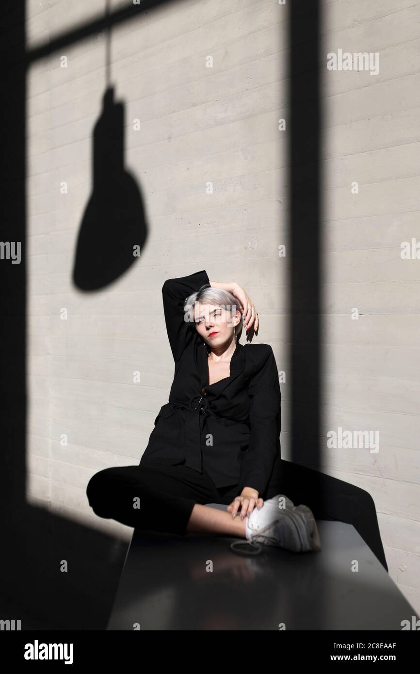 Stylish female professional wearing elegant suit sitting with sunlight ...