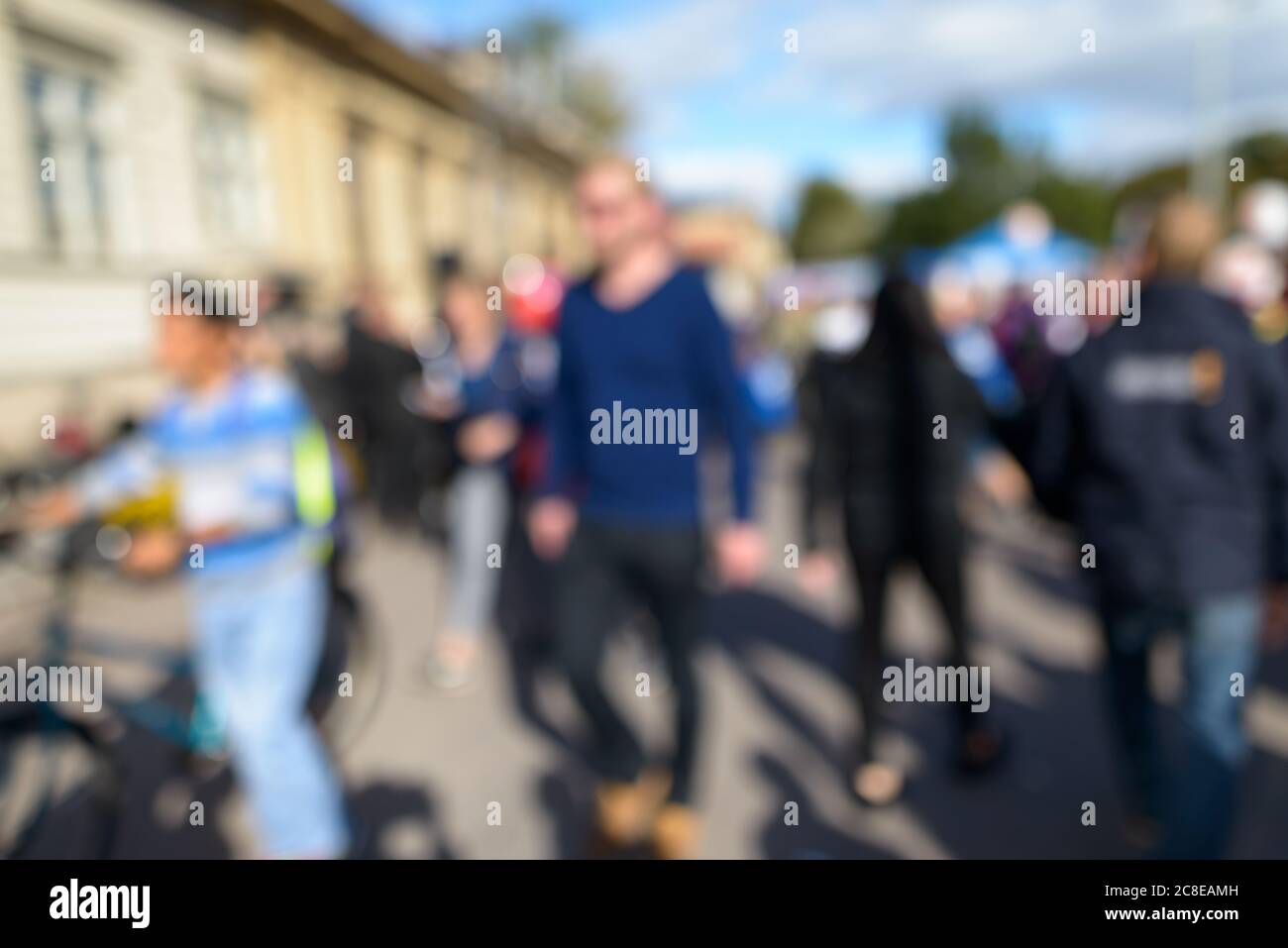 Defocused crowd of people looking busy in the city street on sunny day ...