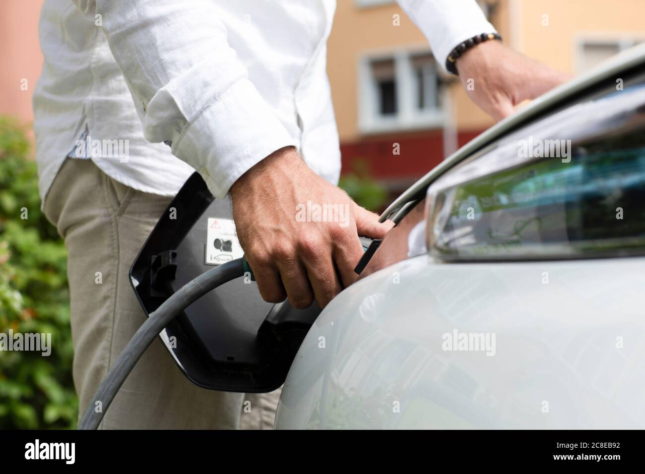 Man charging electric car at station Stock Photo - Alamy