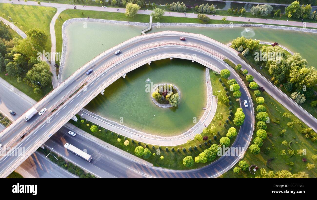 Aerial view of the roundabout on the river. Trees, overpass, buildings ...
