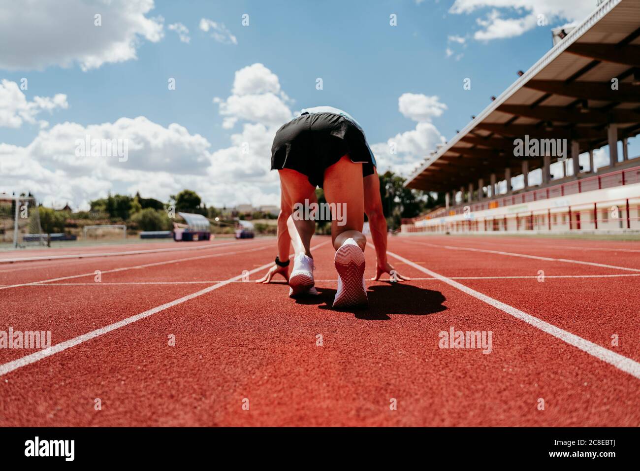 Male athlete in starting position on tartan track Stock Photo - Alamy