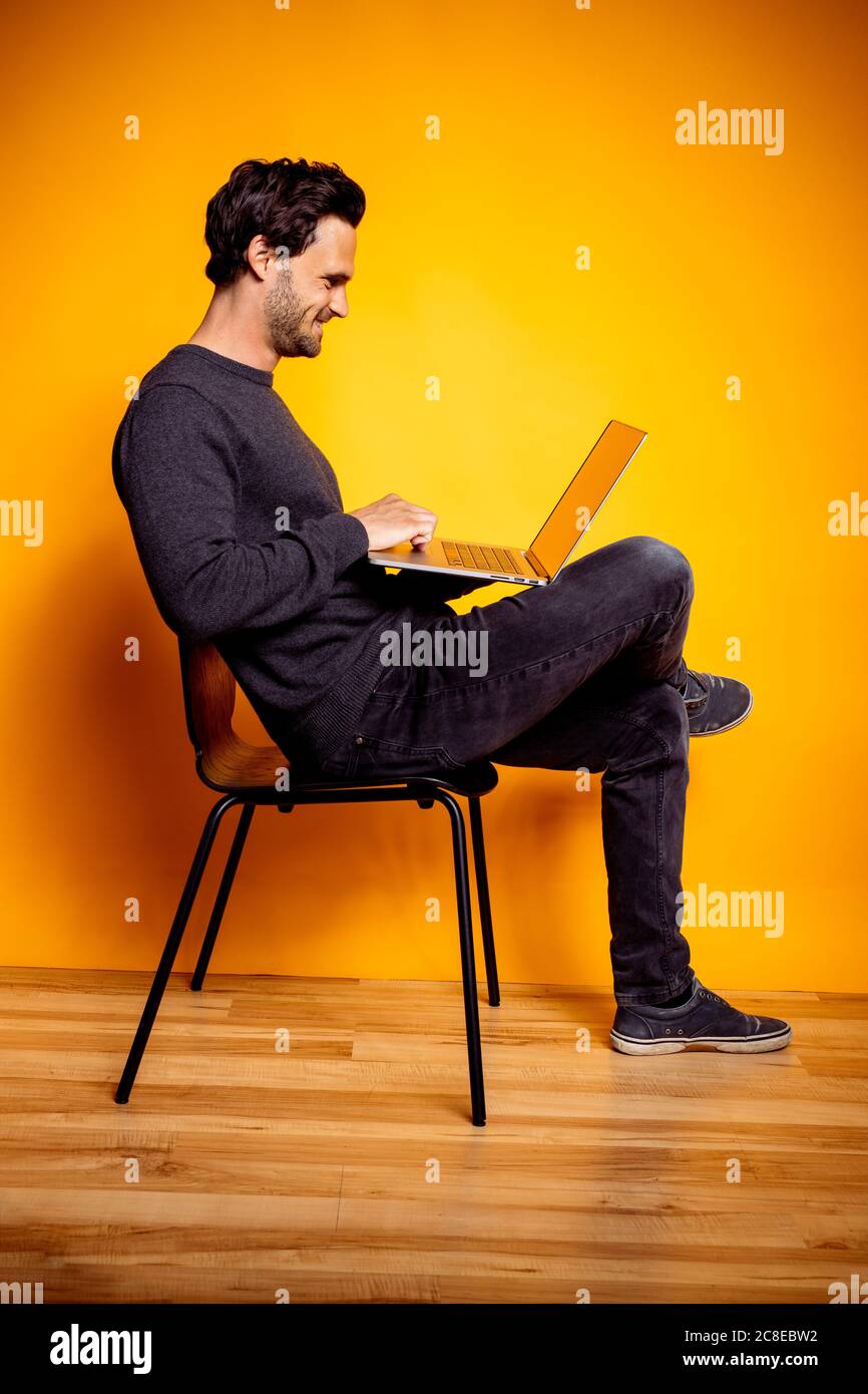 Man sitting on chair laptop hi-res stock photography and images - Alamy