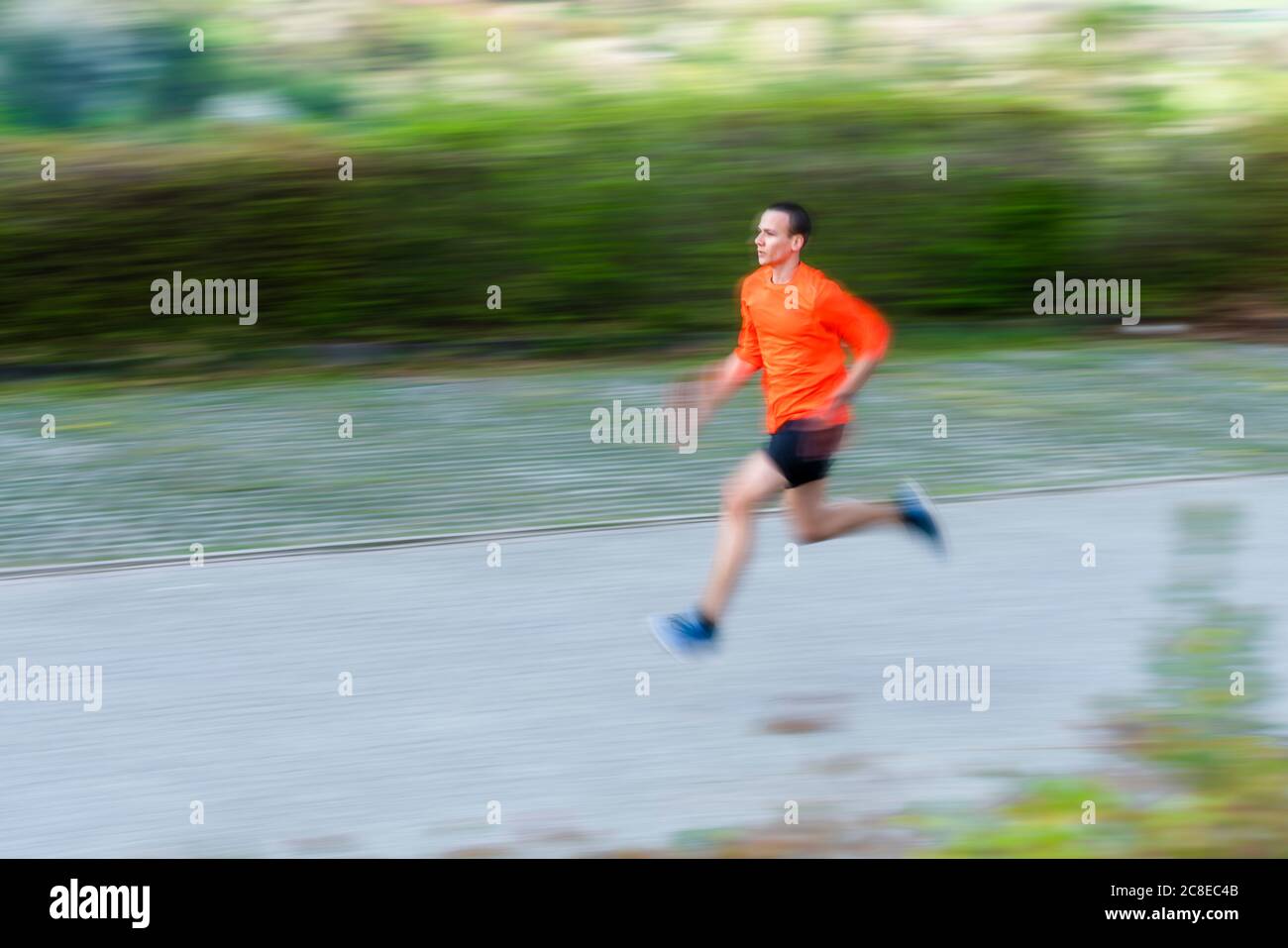 Blurred motion of young man running on footpath Stock Photo - Alamy