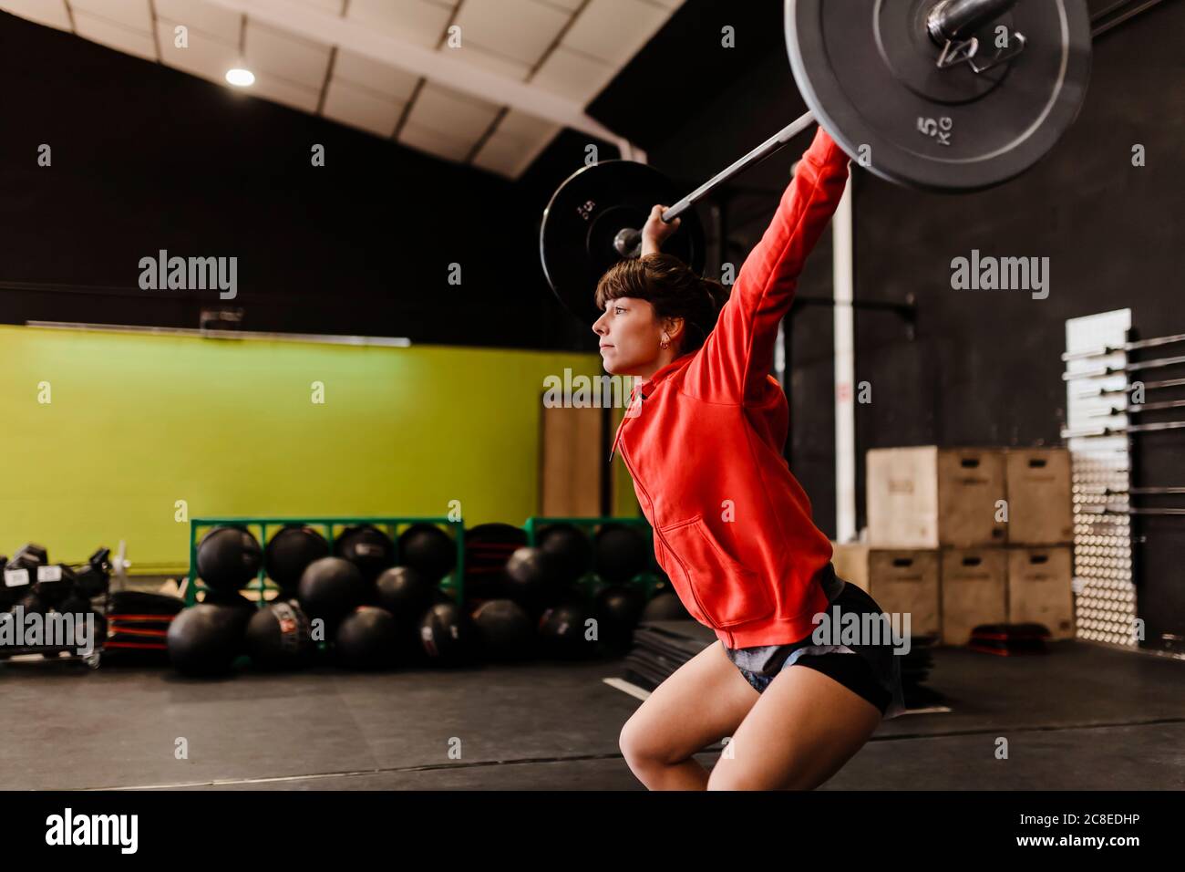 Female athlete lifting deadlift while standing in gym Stock Photo - Alamy